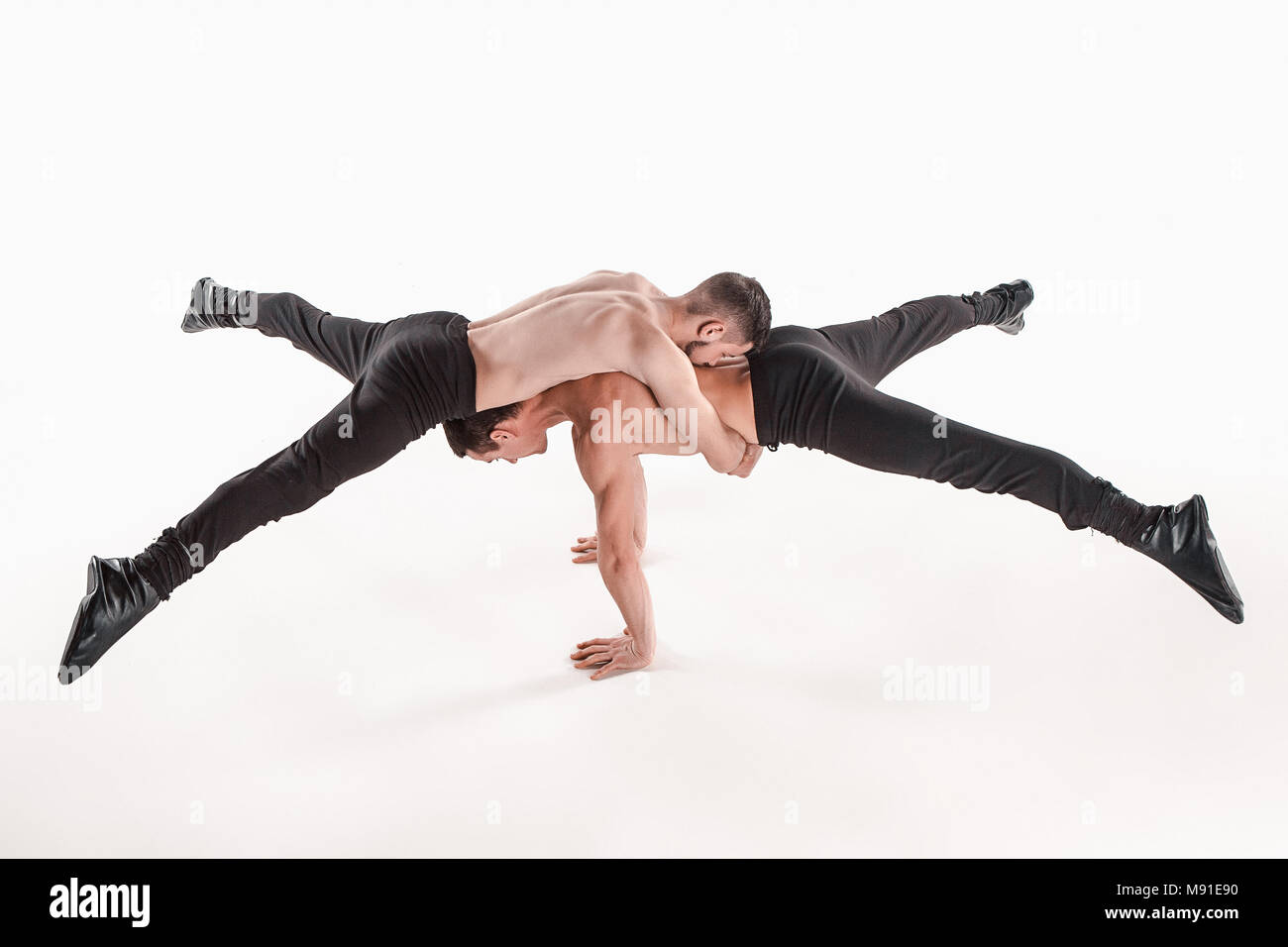 The group of gymnastic acrobatic caucasian men on balance pose Stock ...