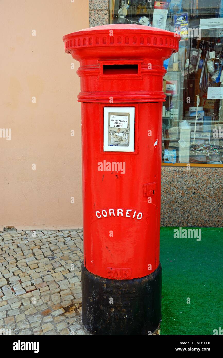 Red cylindrical post box in the town centre, Lagos, Algarve, Portugal ...