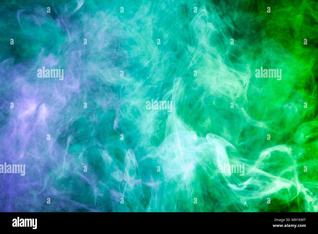 Dense multicolored smoke of blue, and green colors on a black isolated ...