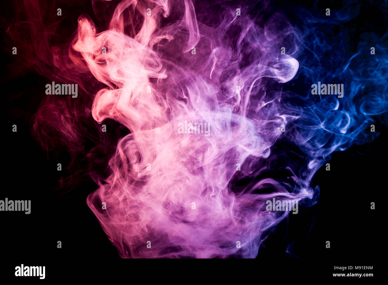 Dense multicolored smoke of blue, pink and red colors on a black ...