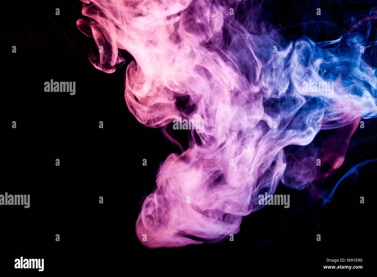 Thick colorful smoke of blue, pink on a black isolated background ...