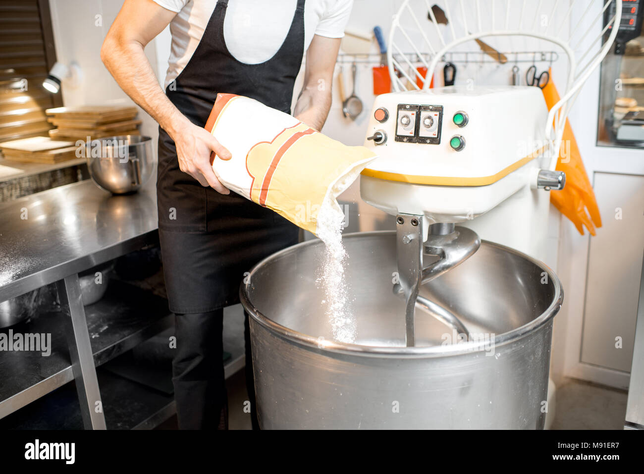 Filling flour into the kneader at the bakery Stock Photo - Alamy