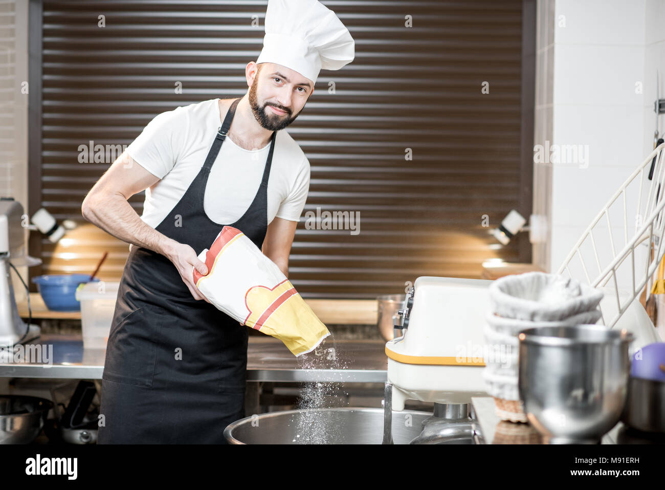 Baker filling flour into the kneader Stock Photo - Alamy