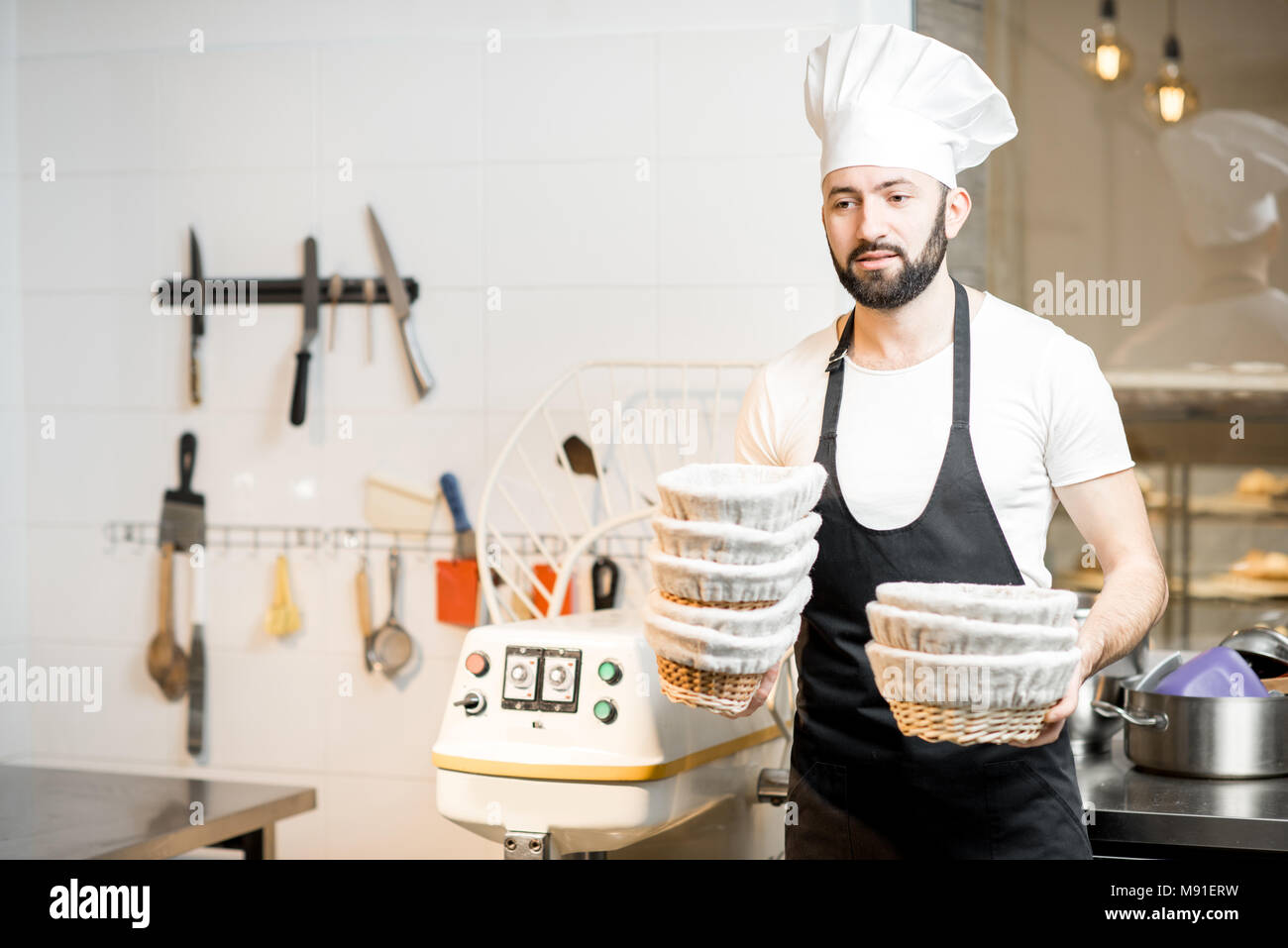 Baker with baking forms at the bakery Stock Photo - Alamy