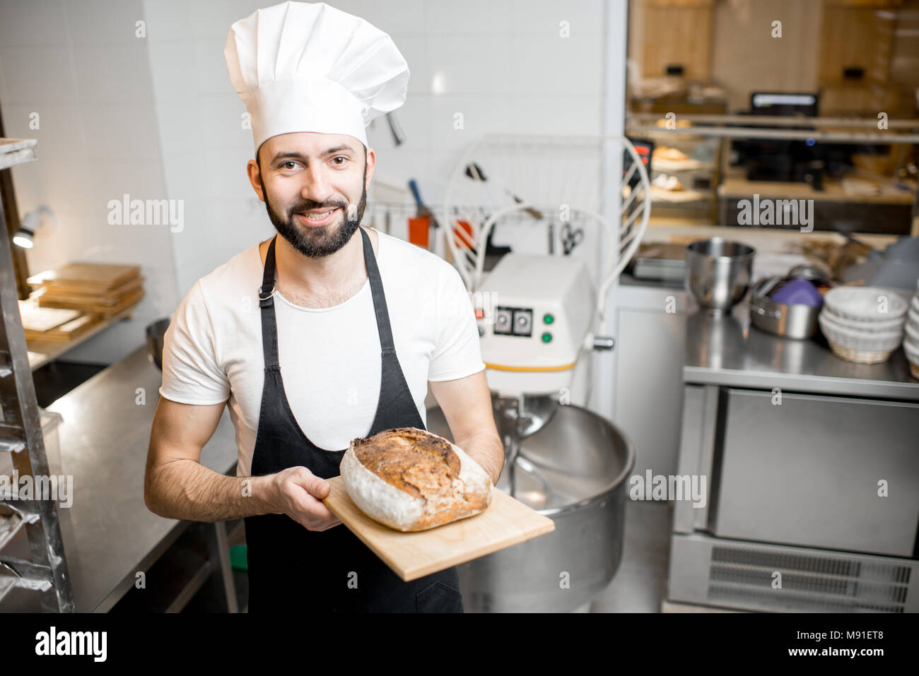 Baker with bread in the bakery Stock Photo - Alamy