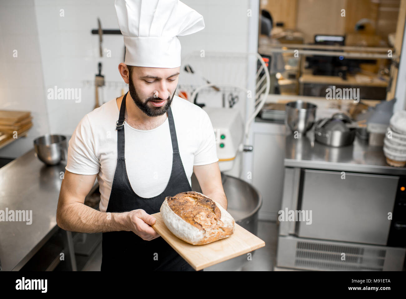 Baker with bread in the bakery Stock Photo - Alamy