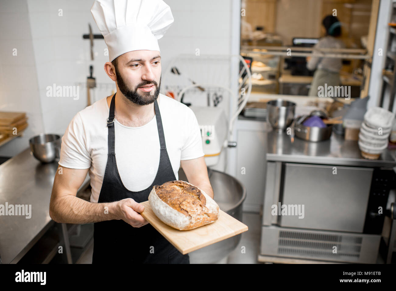 Baker with bread in the bakery Stock Photo - Alamy