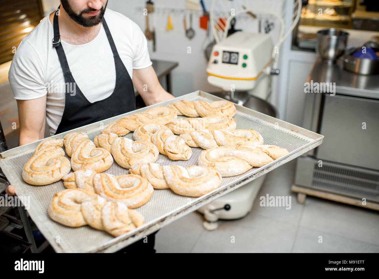 Baker with tray full of sweet pastry Stock Photo - Alamy