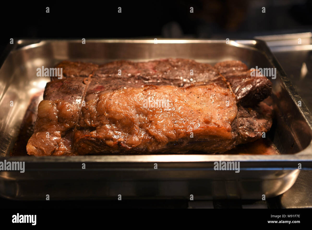 perfectly cooked whole joint of roast beef in a dish ready to carve ...