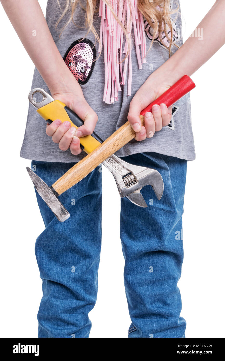 Hammer and adjustable wrench crossed behind her back in the hands of a ...