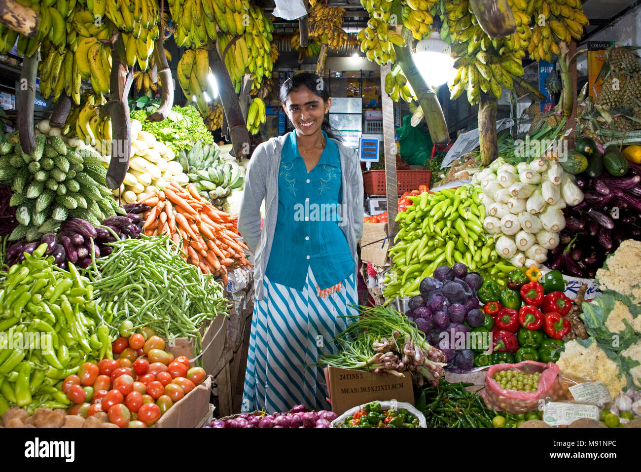 A young Sri Lankan woman trader at her colourful vibrant stall in the ...