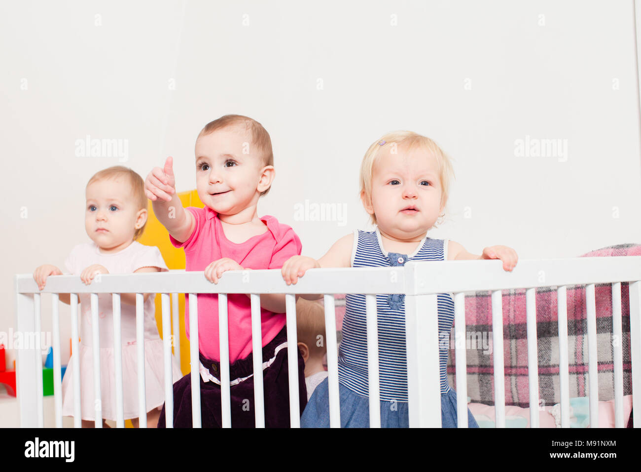 Three baby girls in the crib Stock Photo - Alamy