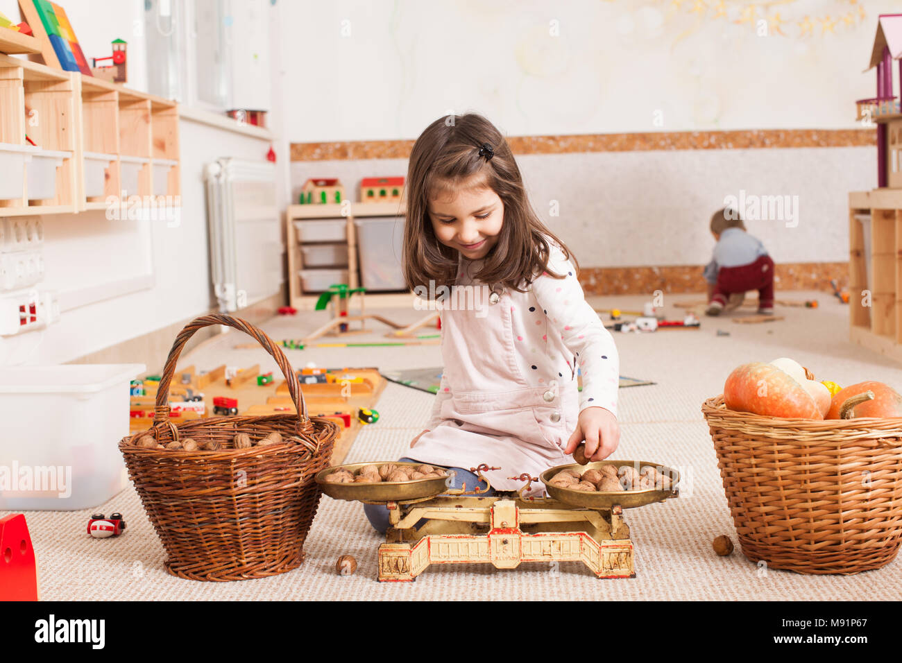 cute little girl is playing with scales Stock Photo - Alamy