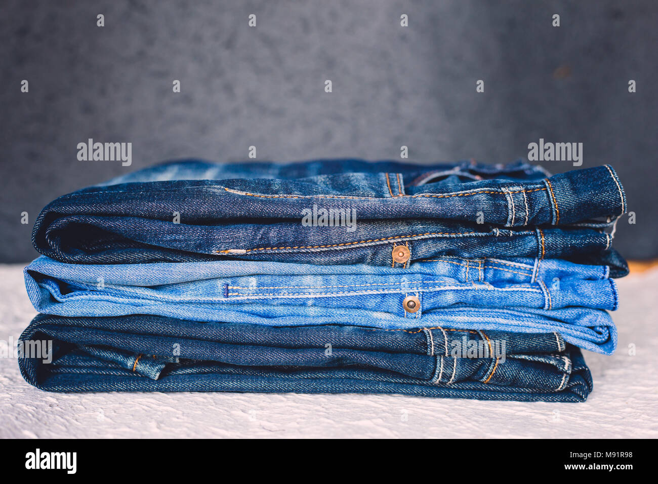 Stack of denim jean with black color background Stock Photo - Alamy