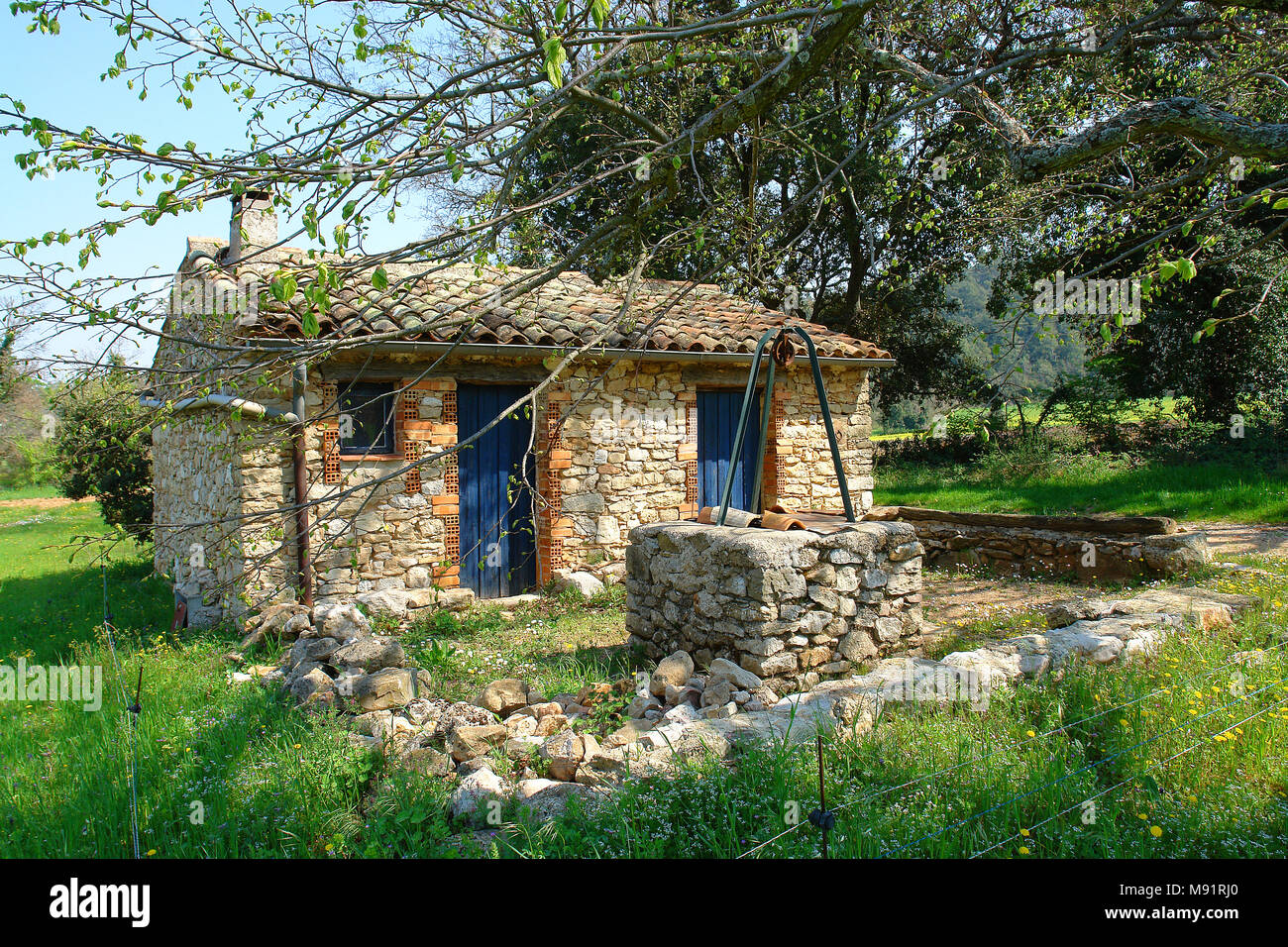 Small field house with a well Stock Photo - Alamy