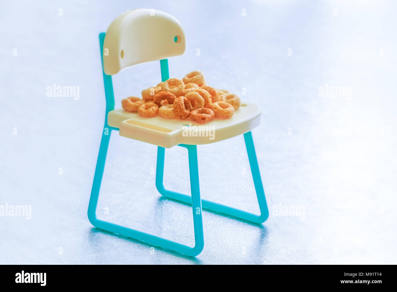 Pile of a lot of round breakfast cereals isolated on miniature chair ...