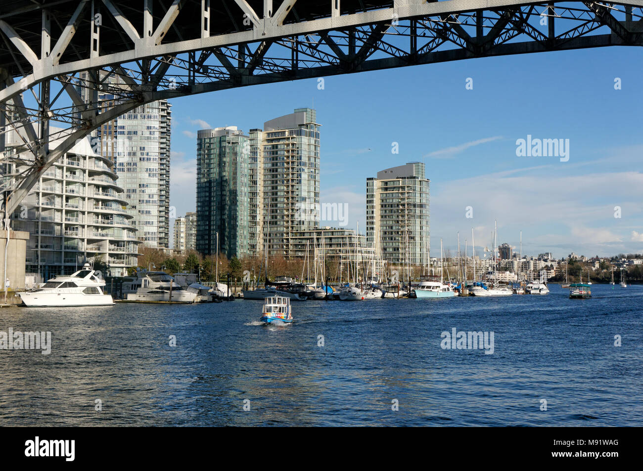 An aquabus ferry on False Creek passing under the Granville Bridge ...