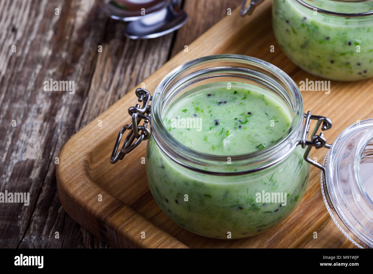Healthy green yogurt sauce in glass jar on wooden background, healthy ...
