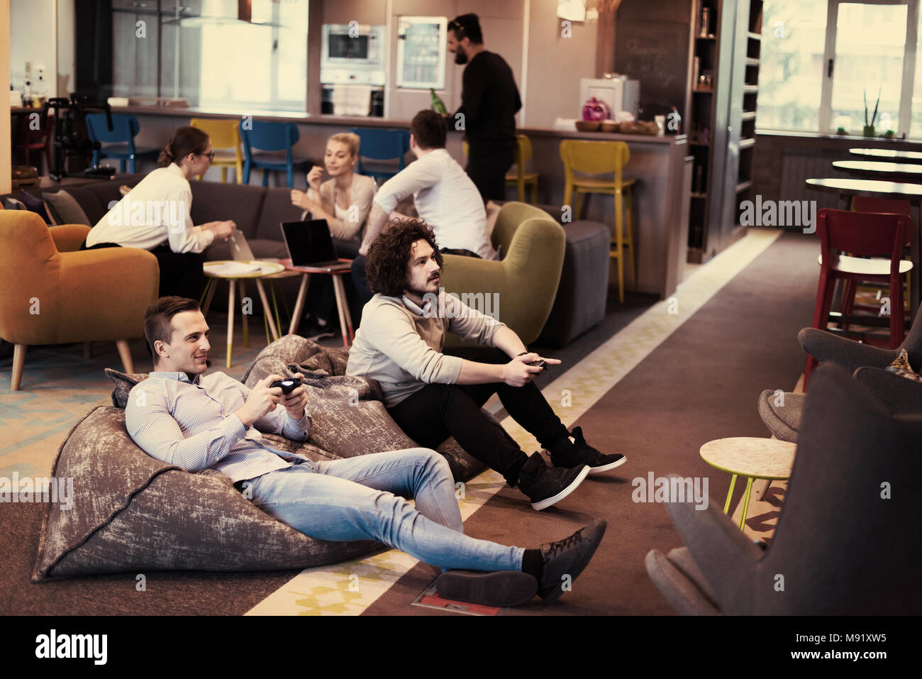 Work hard play hard. Workers Playing computer games in creative startup ...