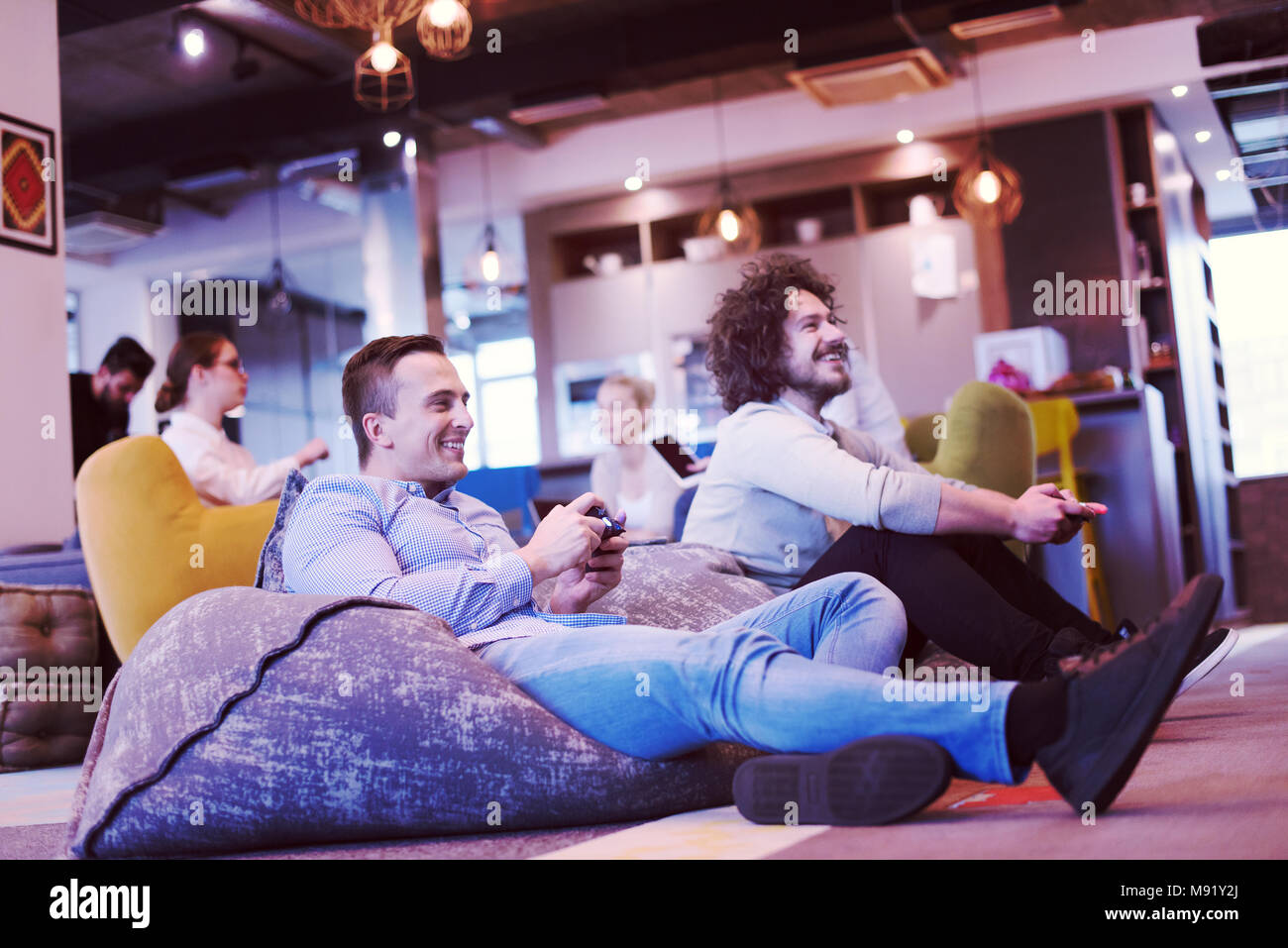 Work hard play hard. Workers Playing computer games in creative startup ...