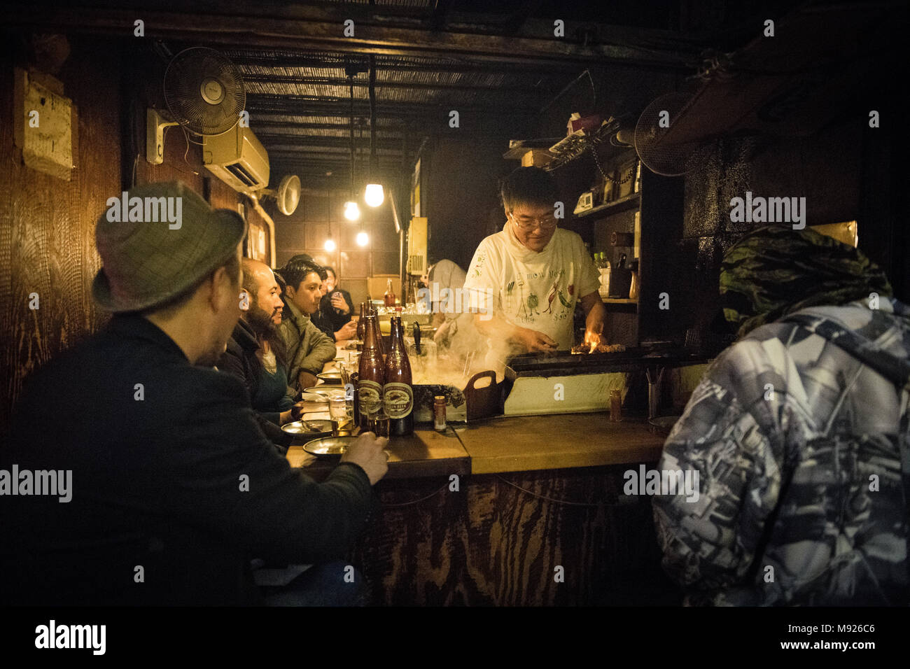 TOKYO, JAPAN - MARCH 21: People enjoy in a small yakiniku bar in ...