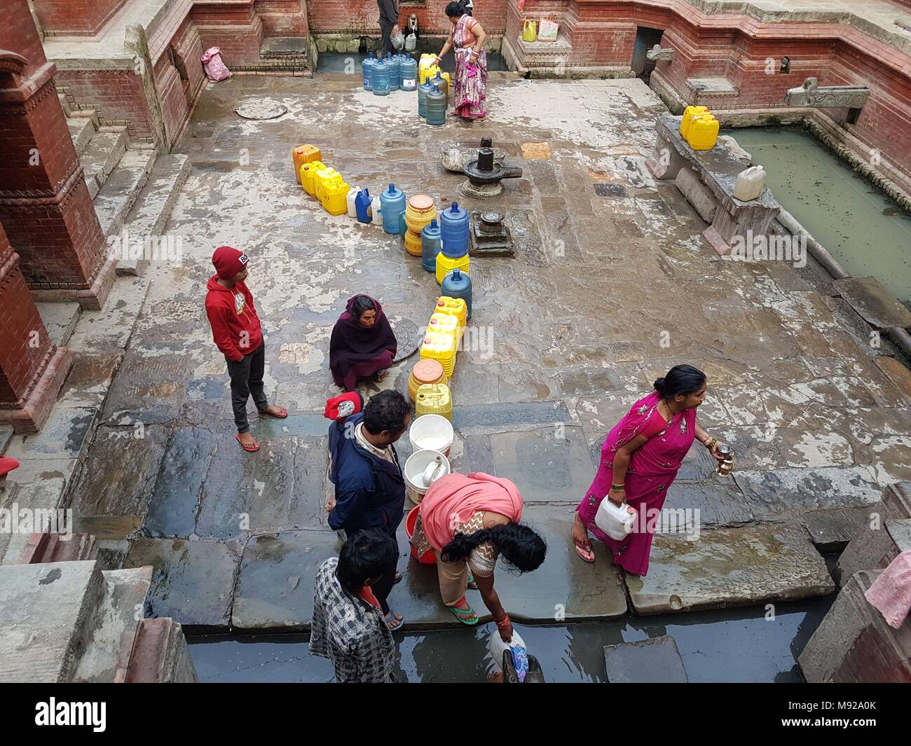 Kathmandu. 22nd Mar, 2018. Nepalese people wait with empty jars to fill ...
