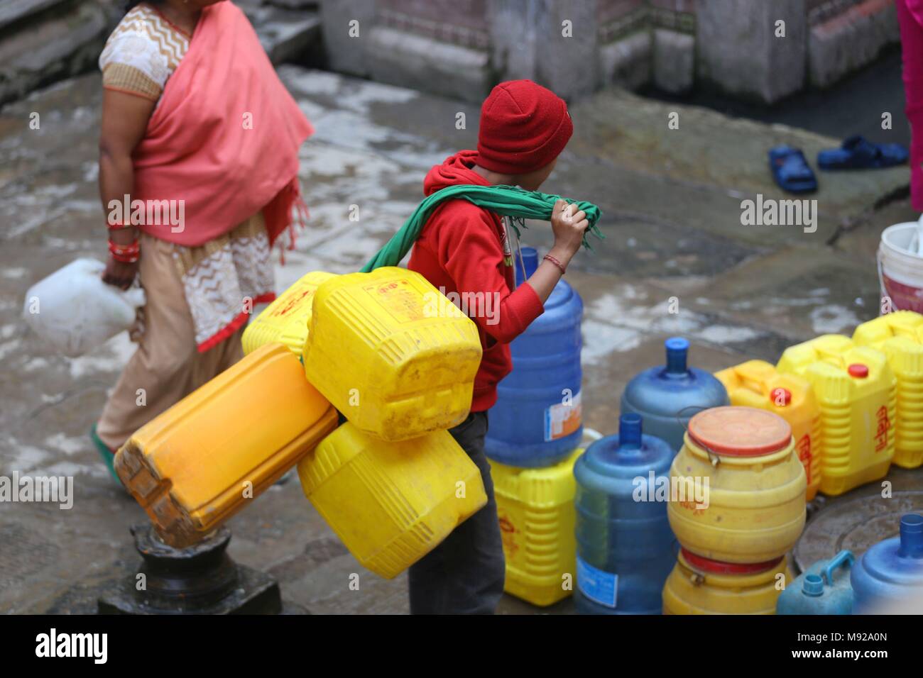 Kathmandu. 22nd Mar, 2018. A boy arrives with empty jars to fill water ...