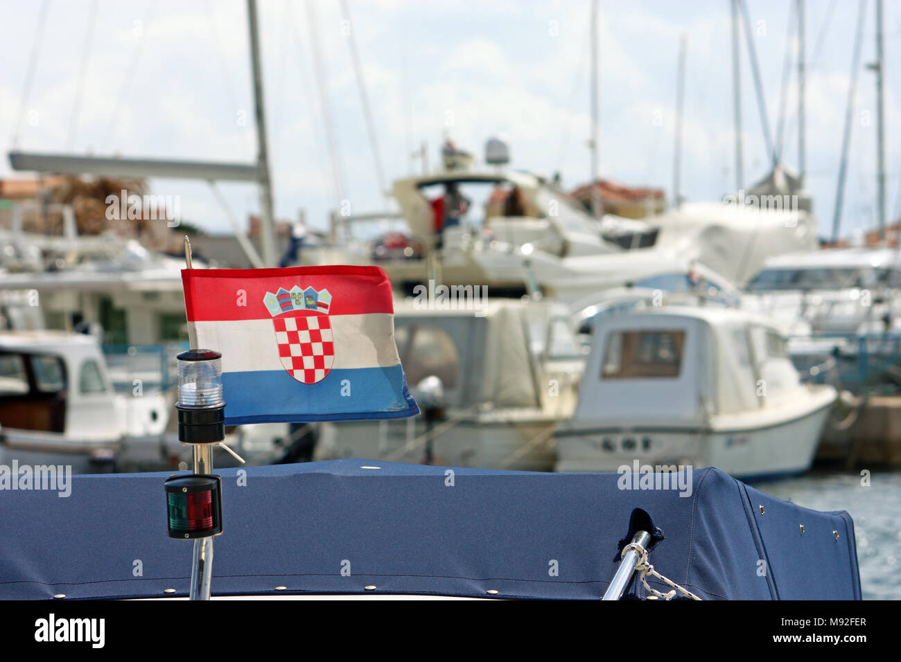 Croatian flag in front of the marina full of small boats and yachts ...