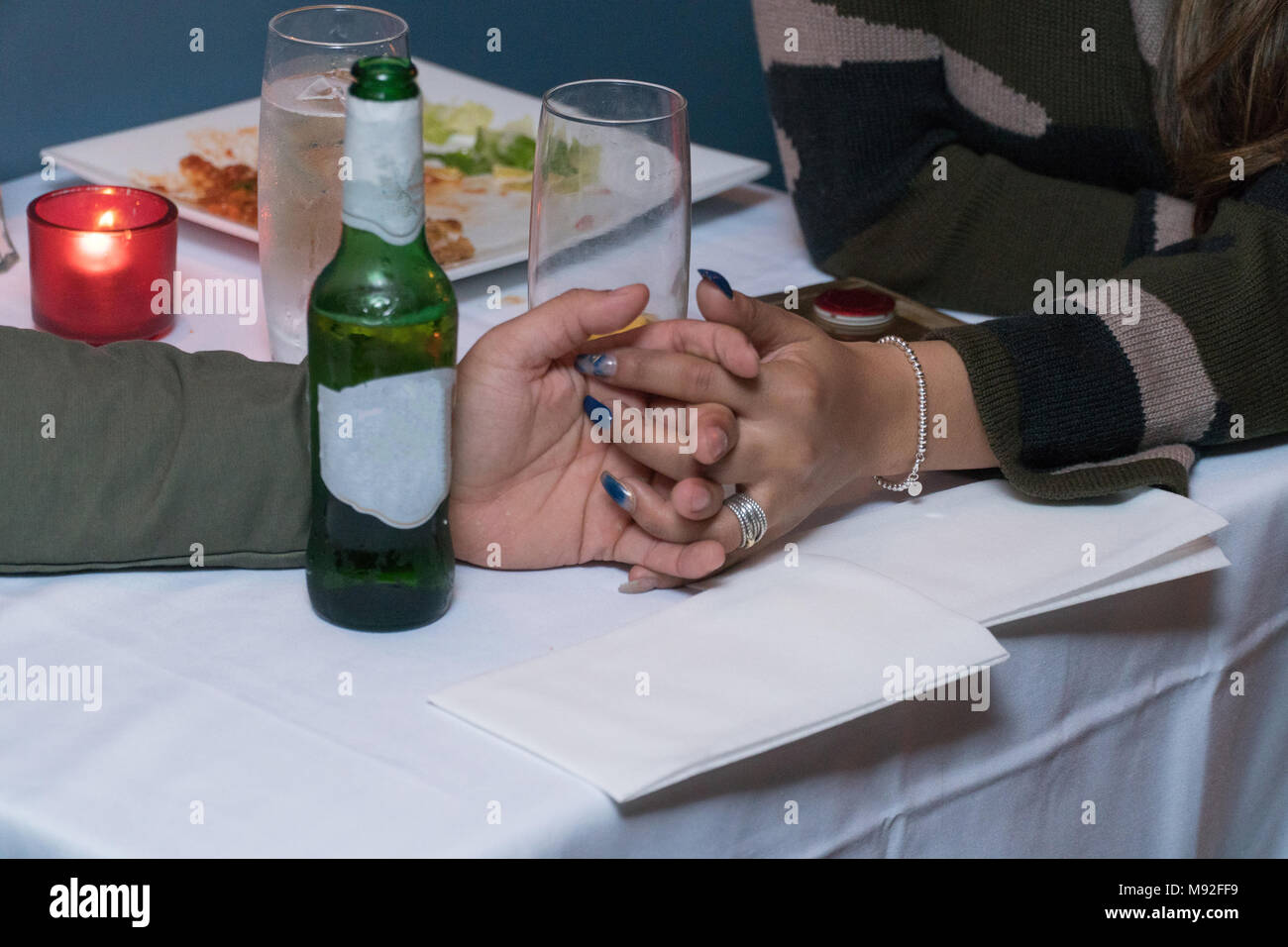 Couple holding hands dinner table hi-res stock photography and images ...
