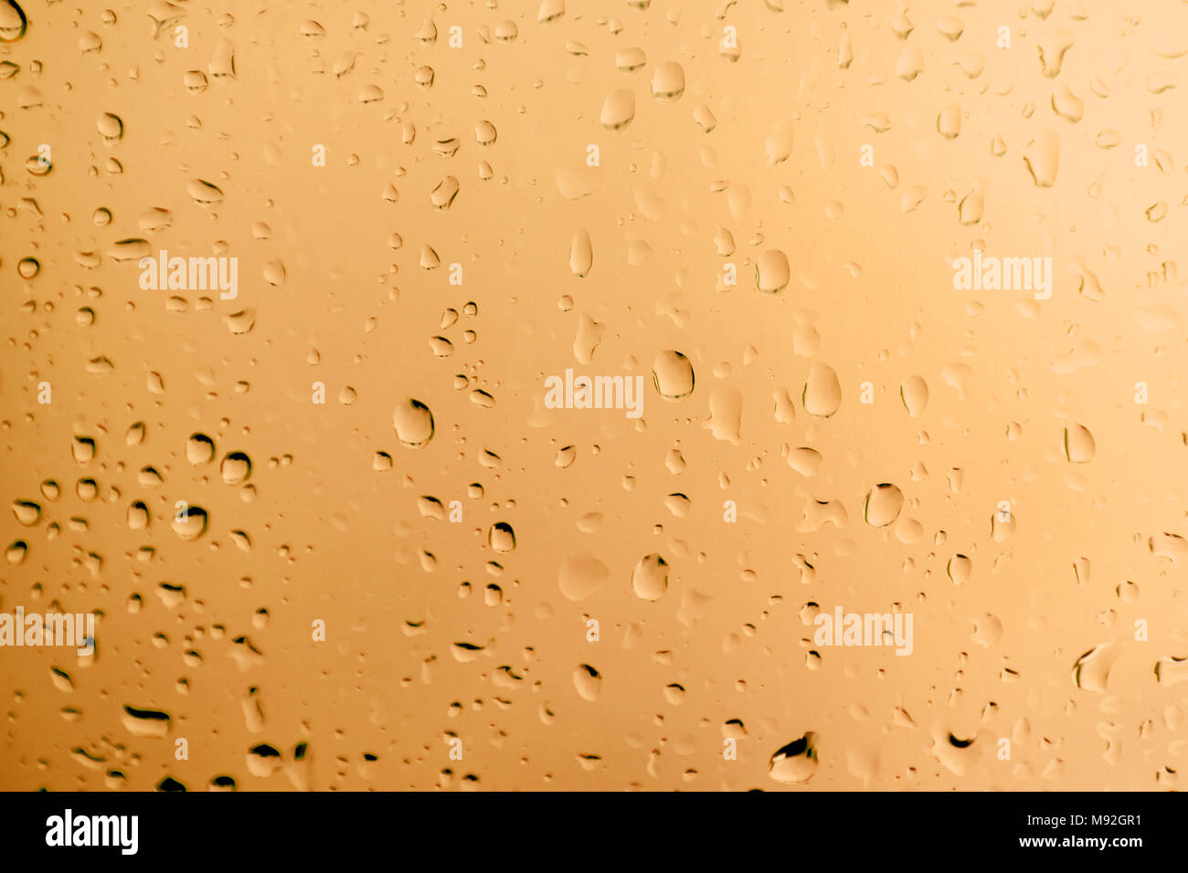 Glass with drops of rain water close up with orange color Stock Photo ...