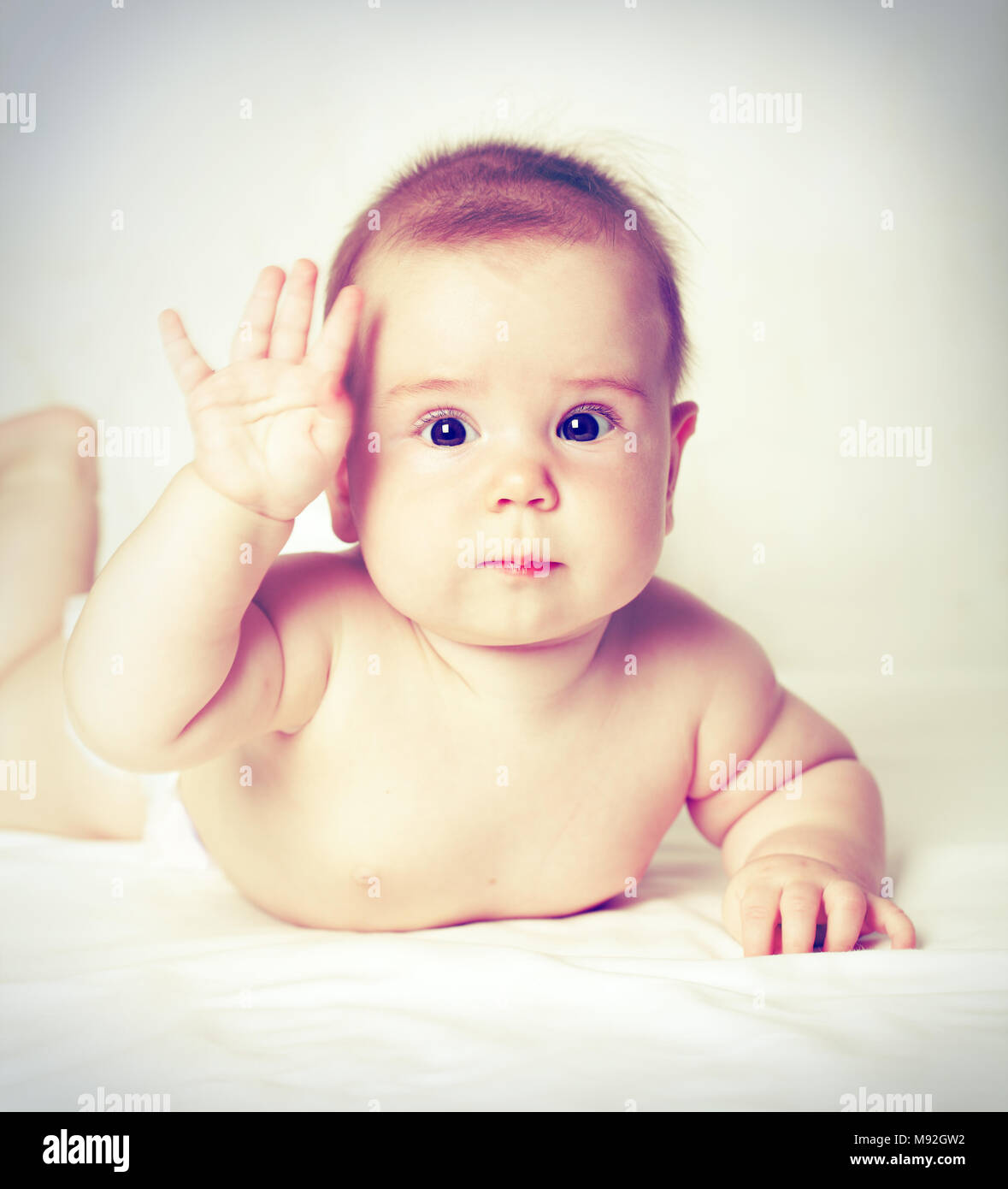 Baby with hand up - hello! Stock Photo - Alamy