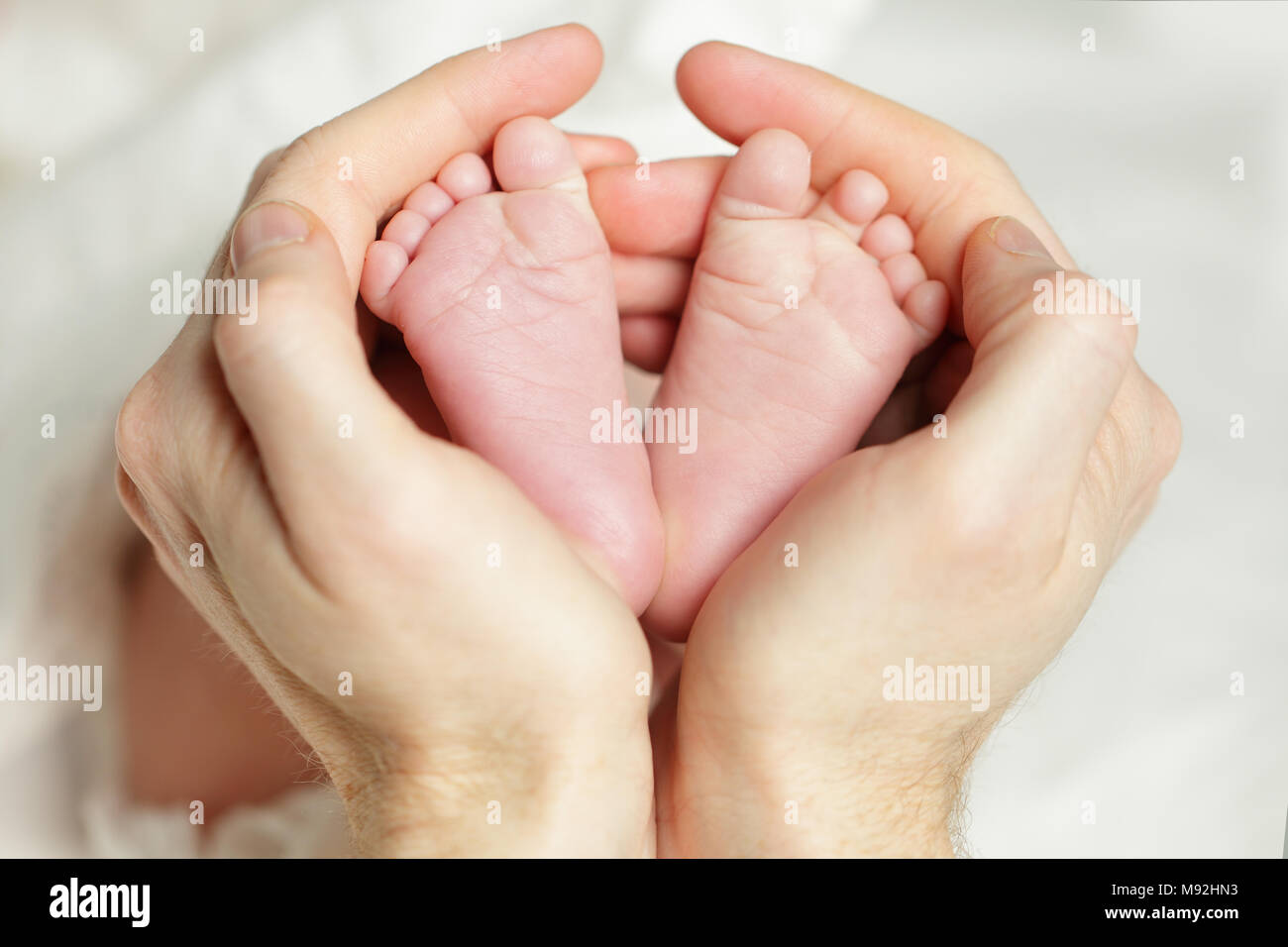 Hand holding baby feet hi-res stock photography and images - Alamy