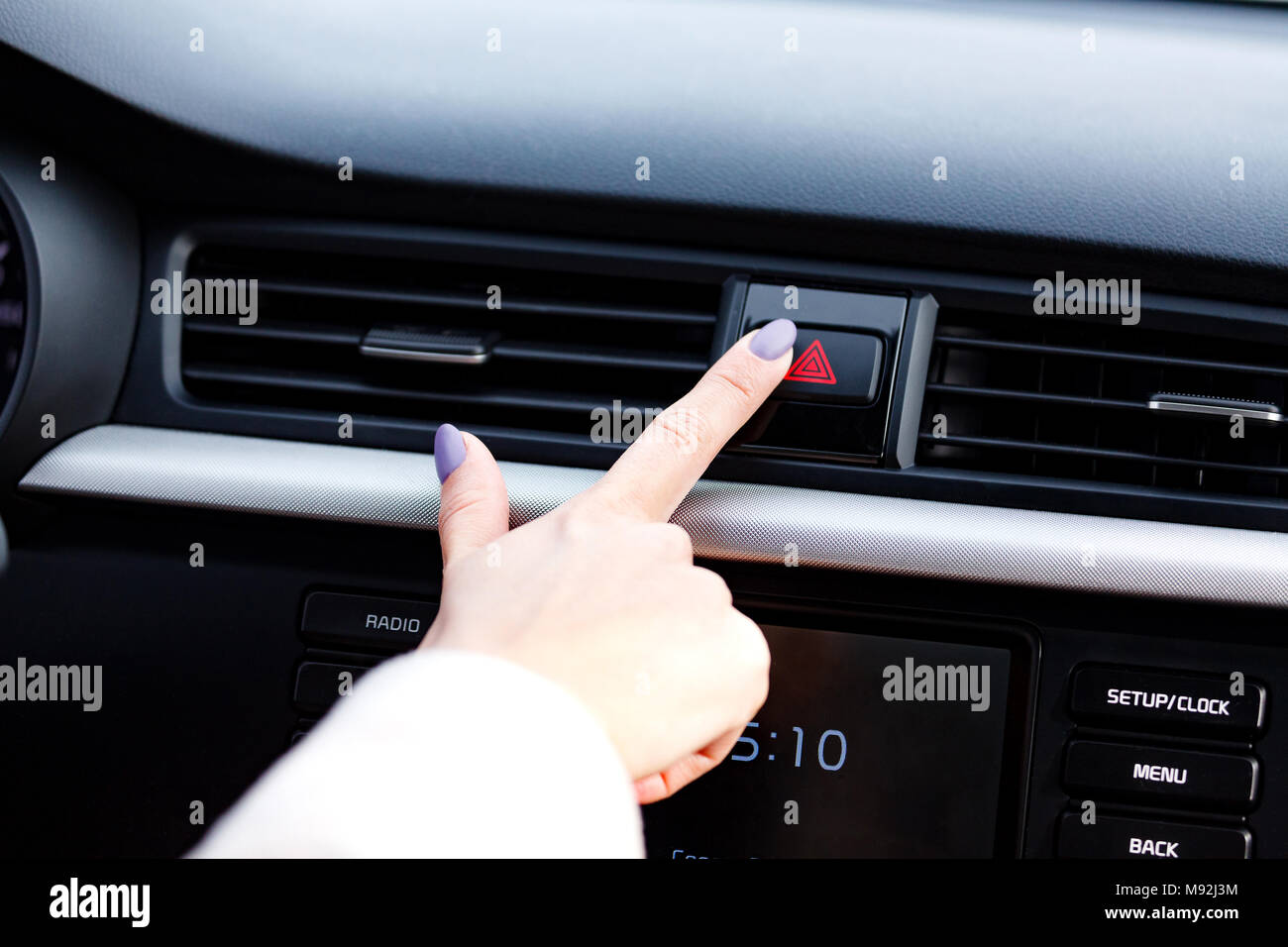 Closeup shot of woman's manicured finger pressing the emergency button ...