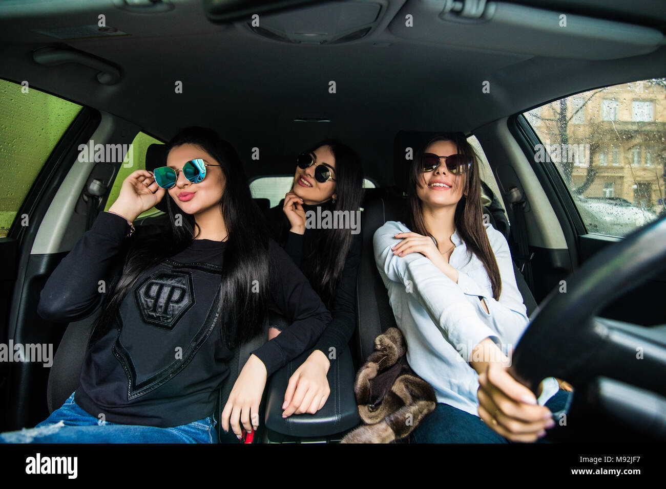 three girls driving in a convertible car and having fun Stock Photo - Alamy