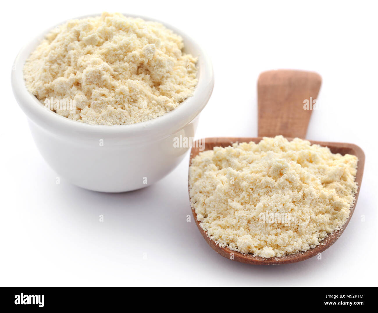 Gram flour in bowl and wooden scoop over white background Stock Photo ...