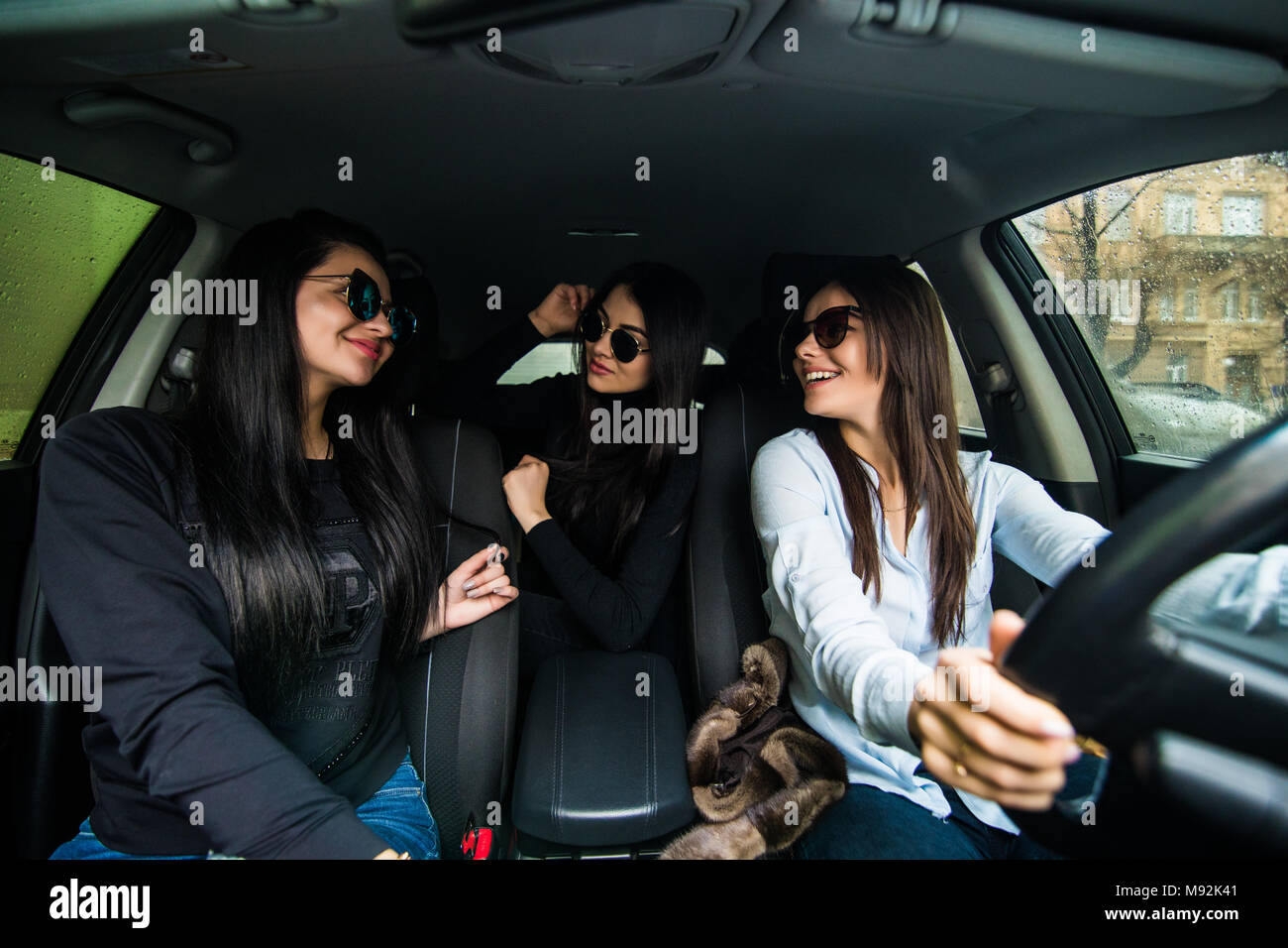 three girls driving in a convertible car and having fun Stock Photo - Alamy
