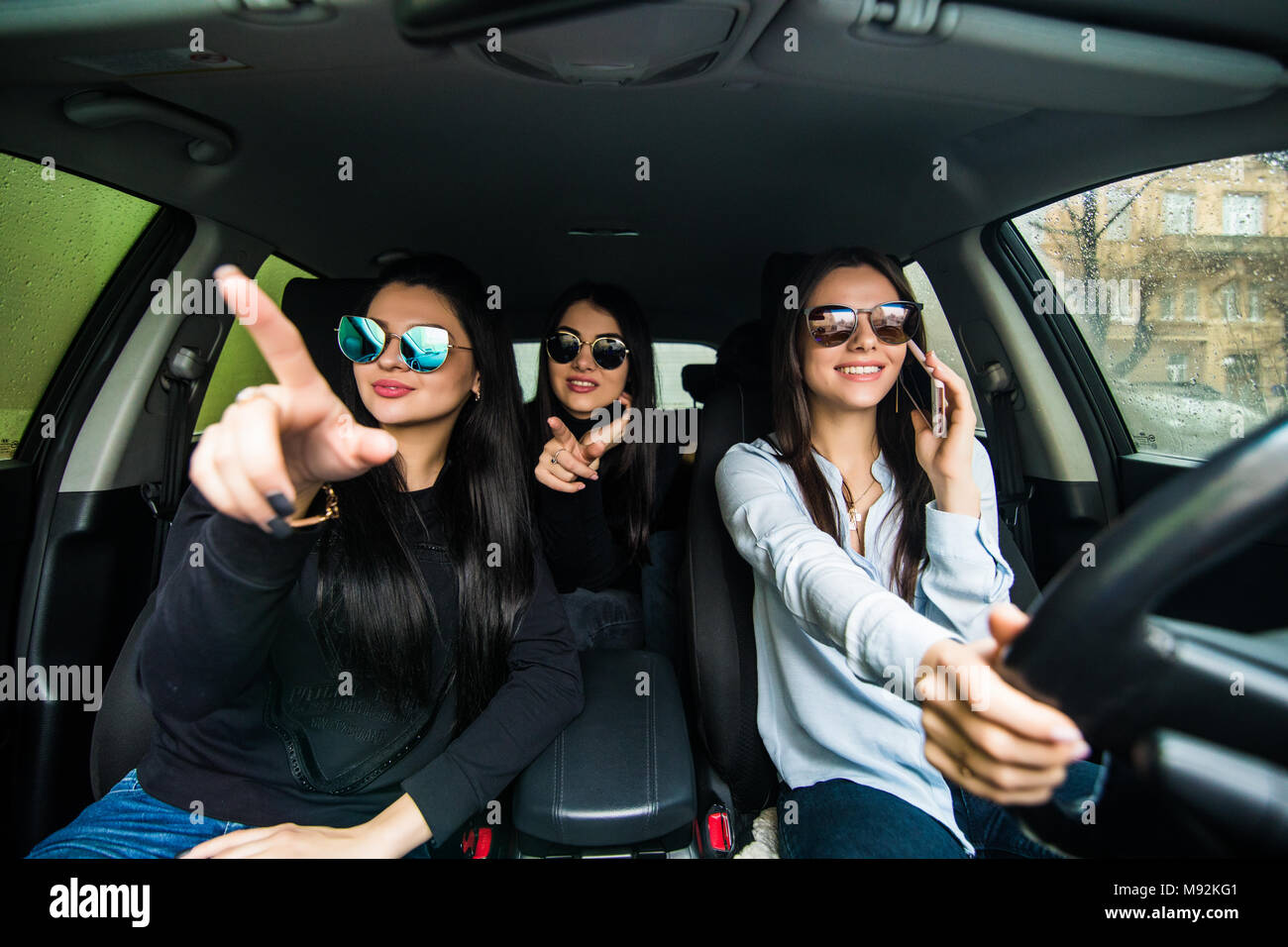 Two women friends talking together in the o car as they go on a road ...