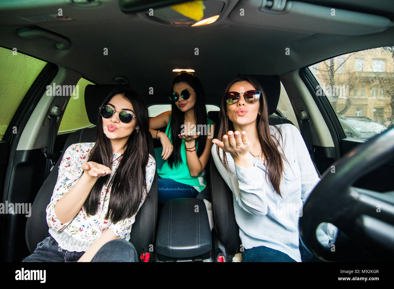three girls driving in a convertible car and having fun Stock Photo - Alamy