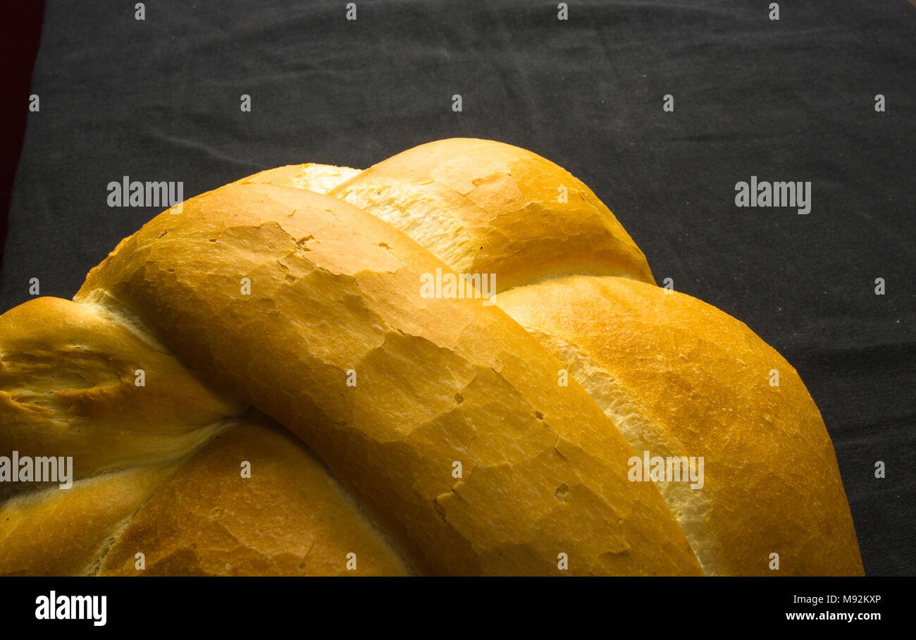 fresh braided loaf of white wheat bread on black background Stock Photo ...