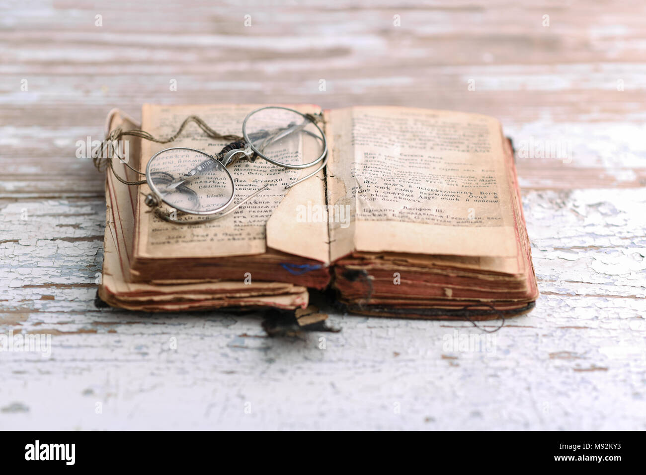 Ancient Christian prayer book with old spectacles, Old Slavic language ...