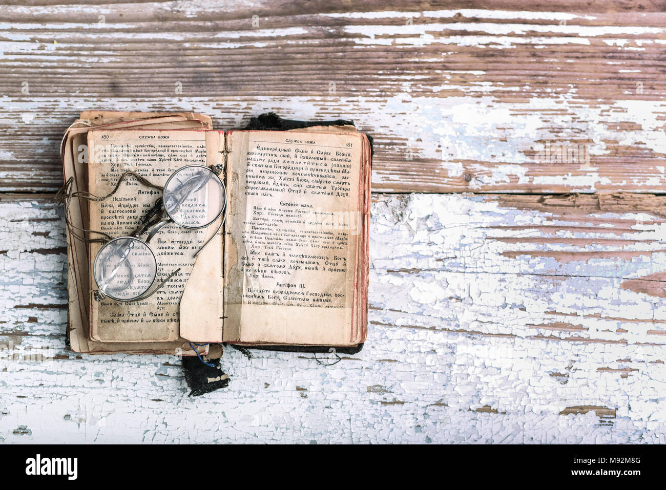 Ancient Christian prayer book with old spectacles, Old Slavic language ...