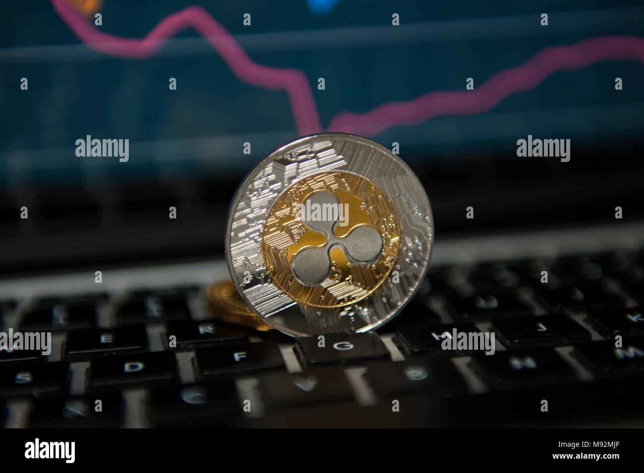 Ripple cryptocurrency coins seen in front stock market graphs Stock ...