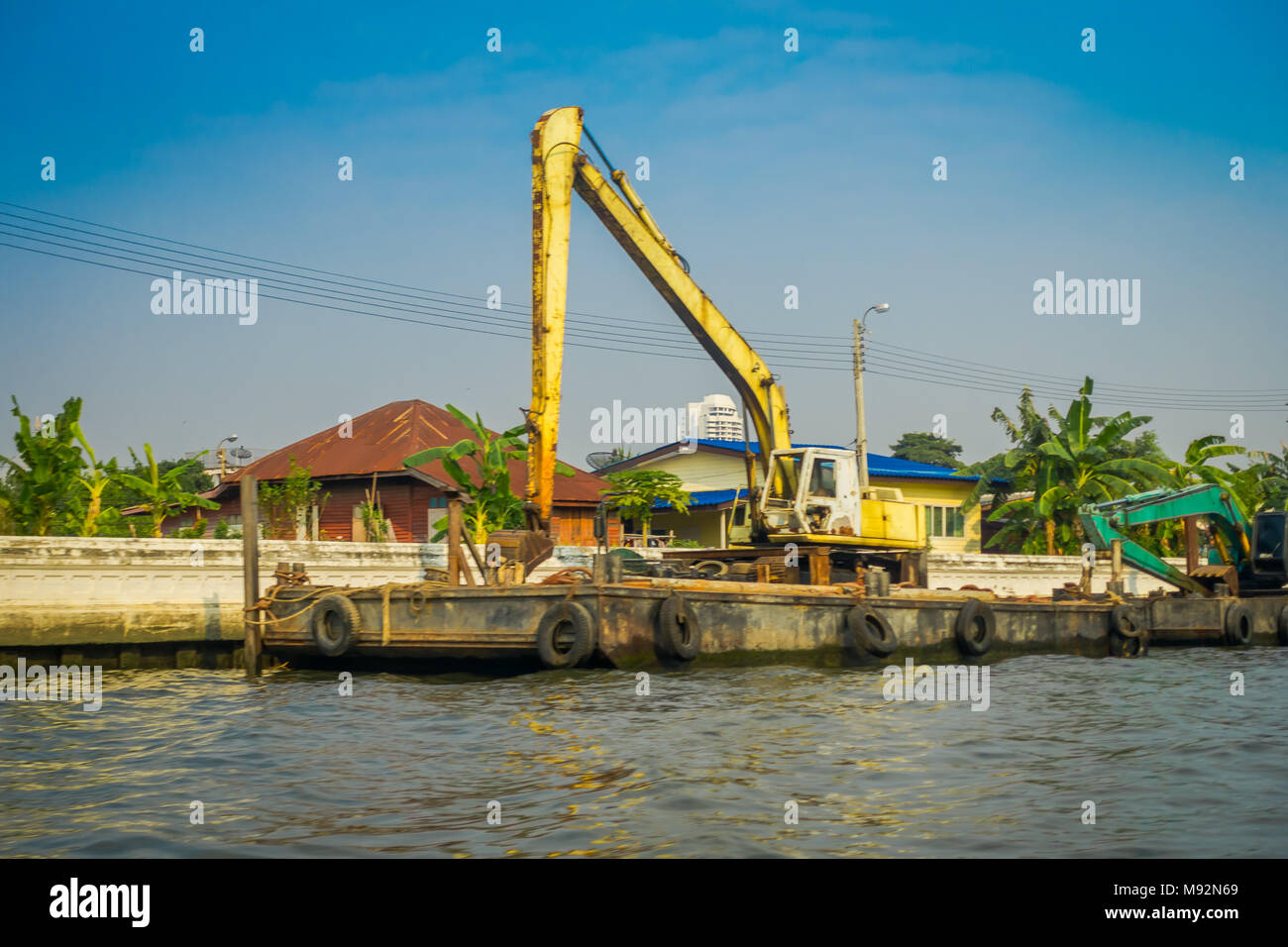 Outdoor view of heavy machinary over a floating platform, at riverside ...
