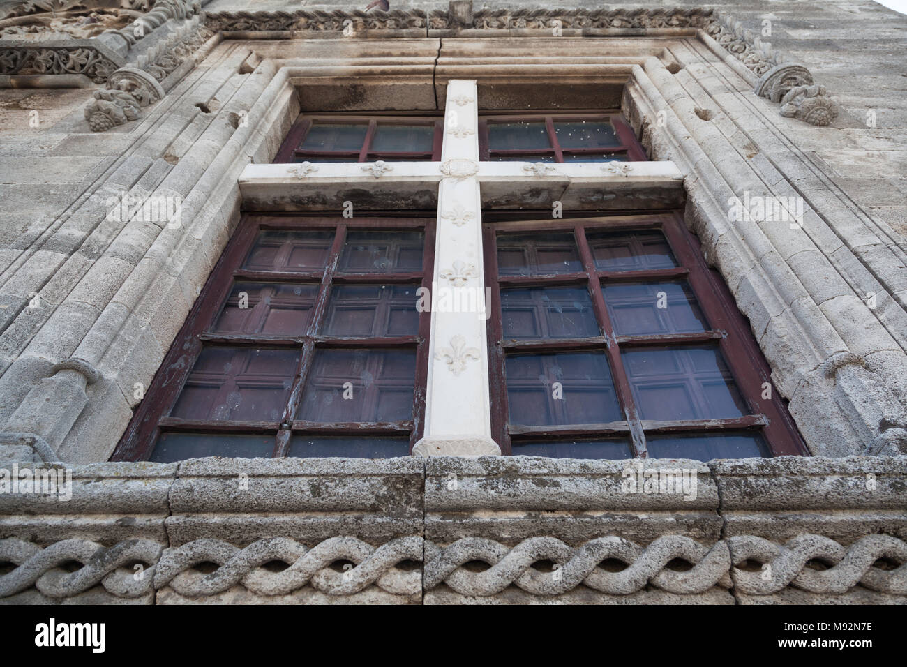 Window with a white stone cross in the medieval castle of Rhodes ...