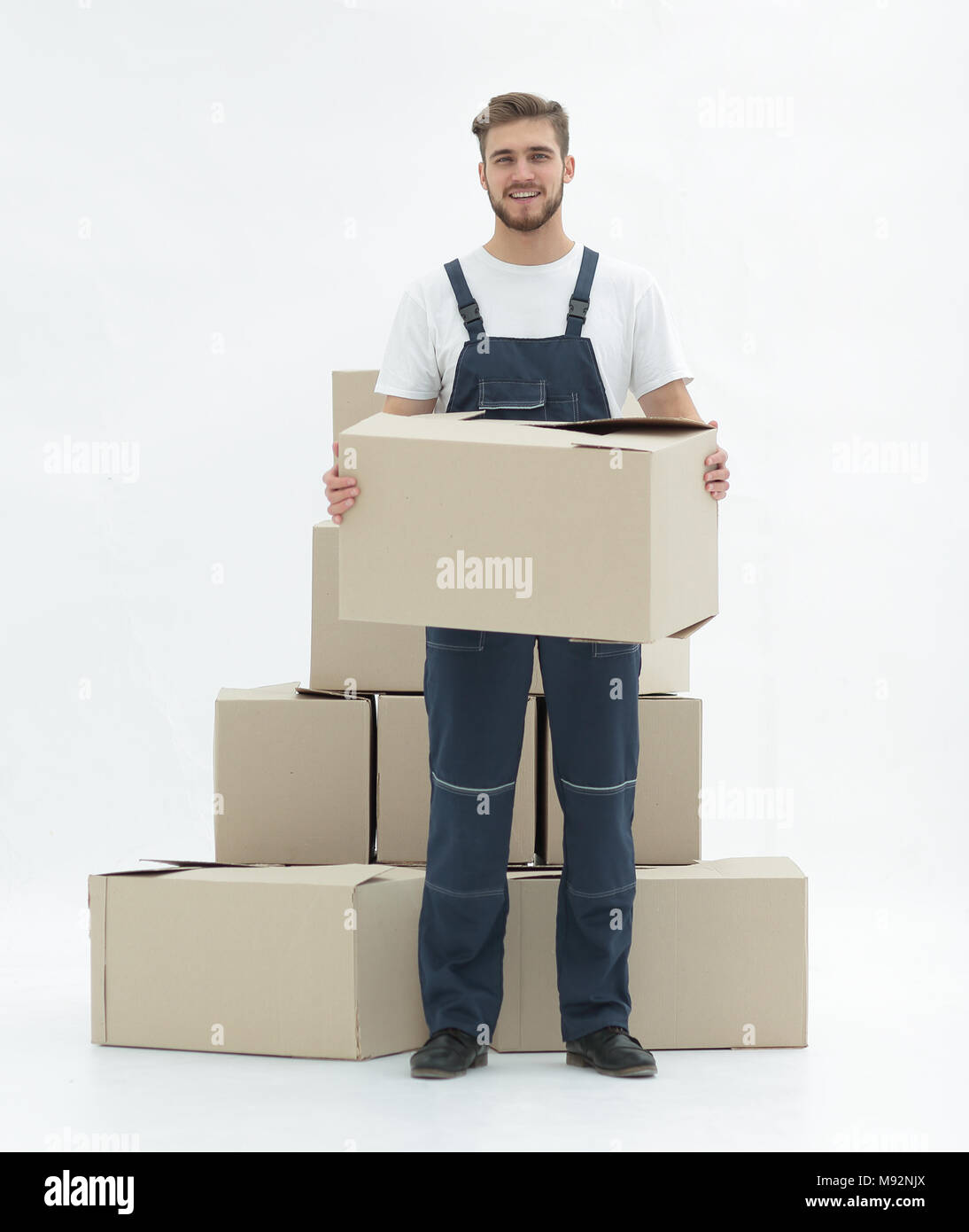 Young man carrying a box to the pile of boxes Stock Photo - Alamy