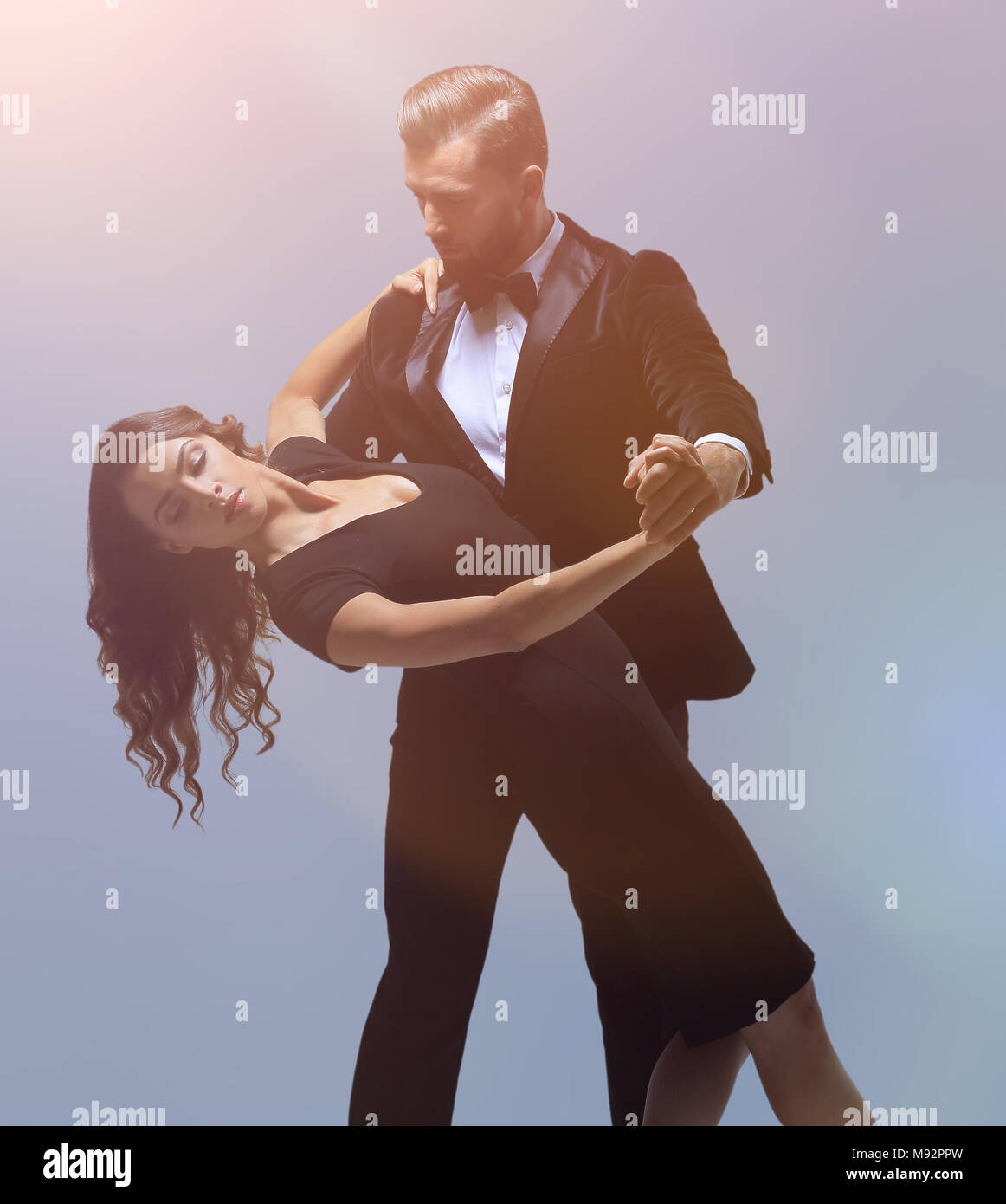 Well-dressed retro couple dancing tango over grey studio background Stock Photo - Alamy