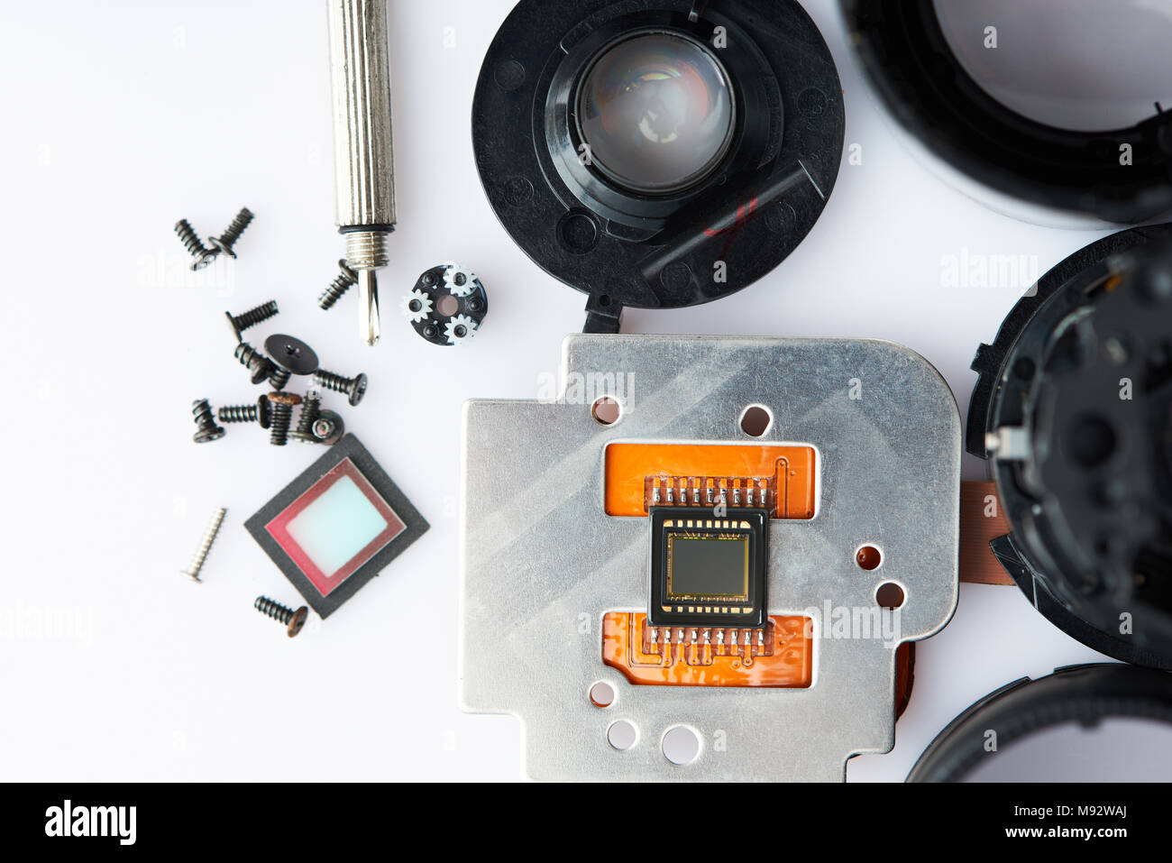 Small digtial parts of modern camera lay on white table. Broken ...