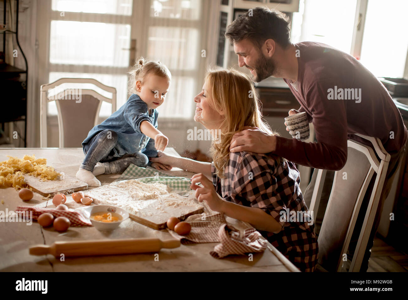 Happy family making pasta in the kitchen at home Stock Photo - Alamy
