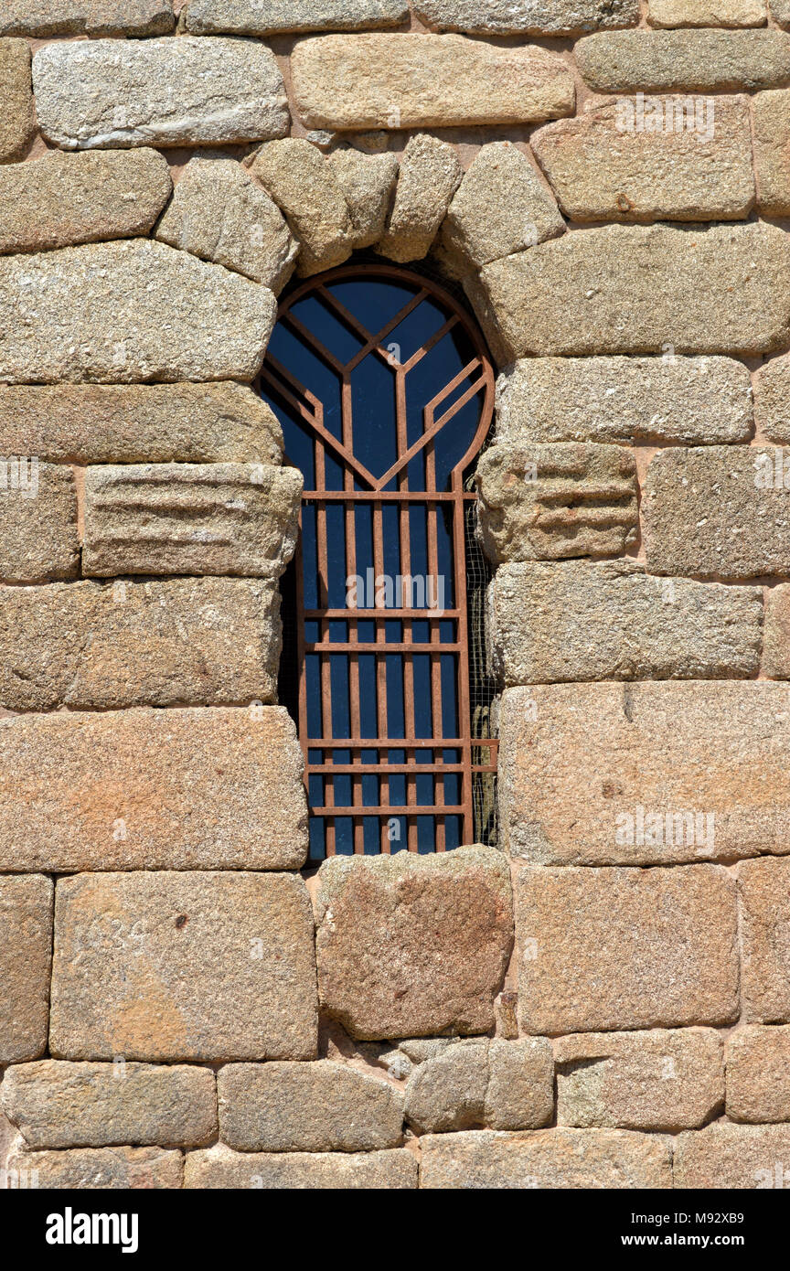 window with horseshoe and modern iron fence in a wall of stone ashlars ...