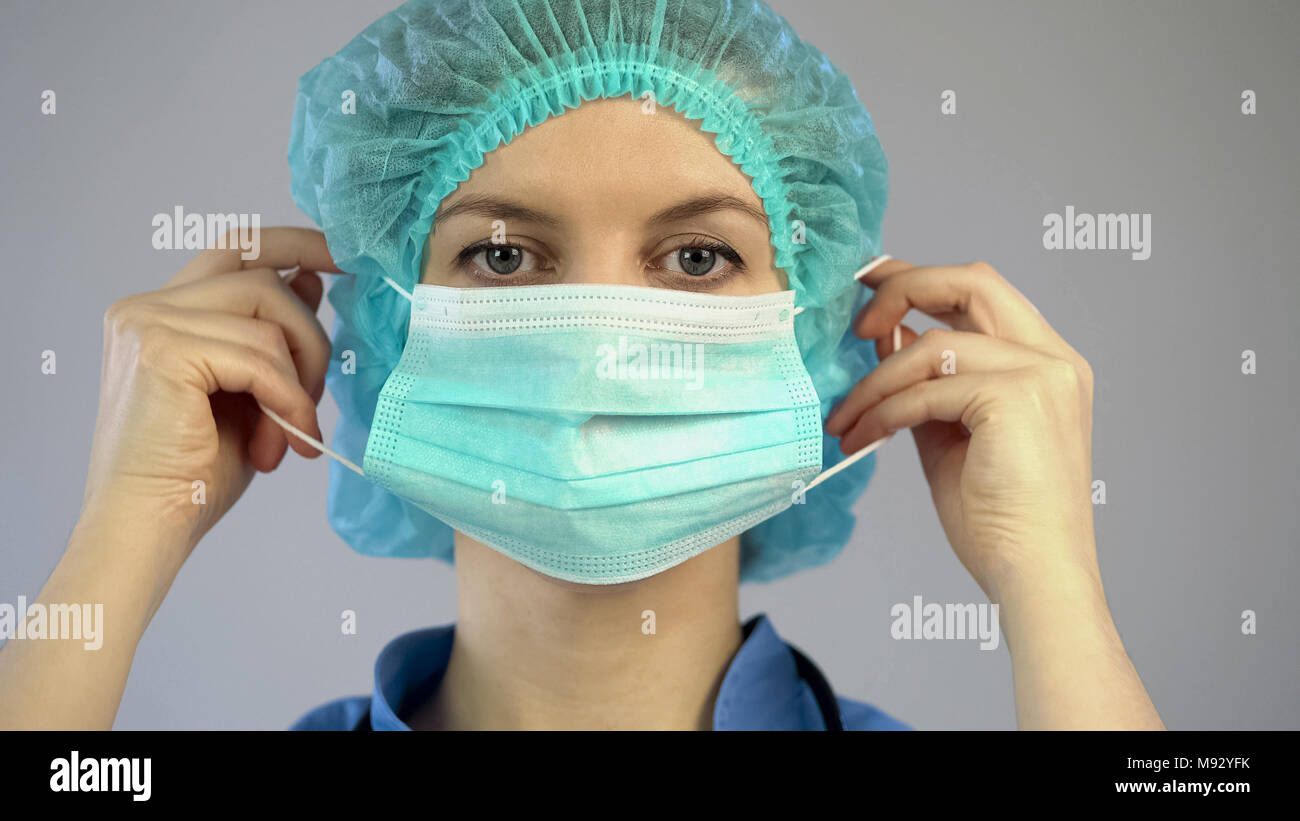 Surgeon putting on mask, doctor preparing for the procedure, examining ...